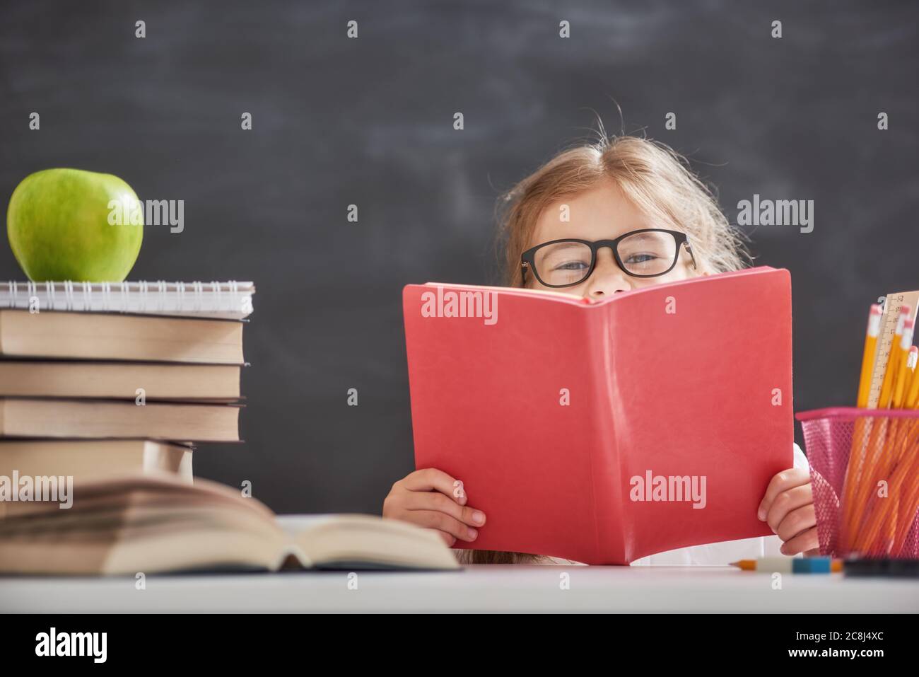 Back to school and happy time! Cute industrious child is sitting at a ...