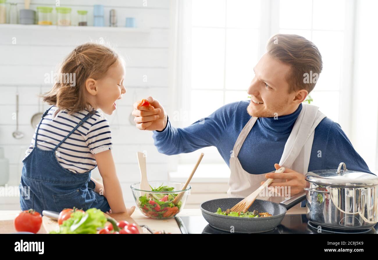 Healthy food at home. Happy family in the kitchen. Father and child ...