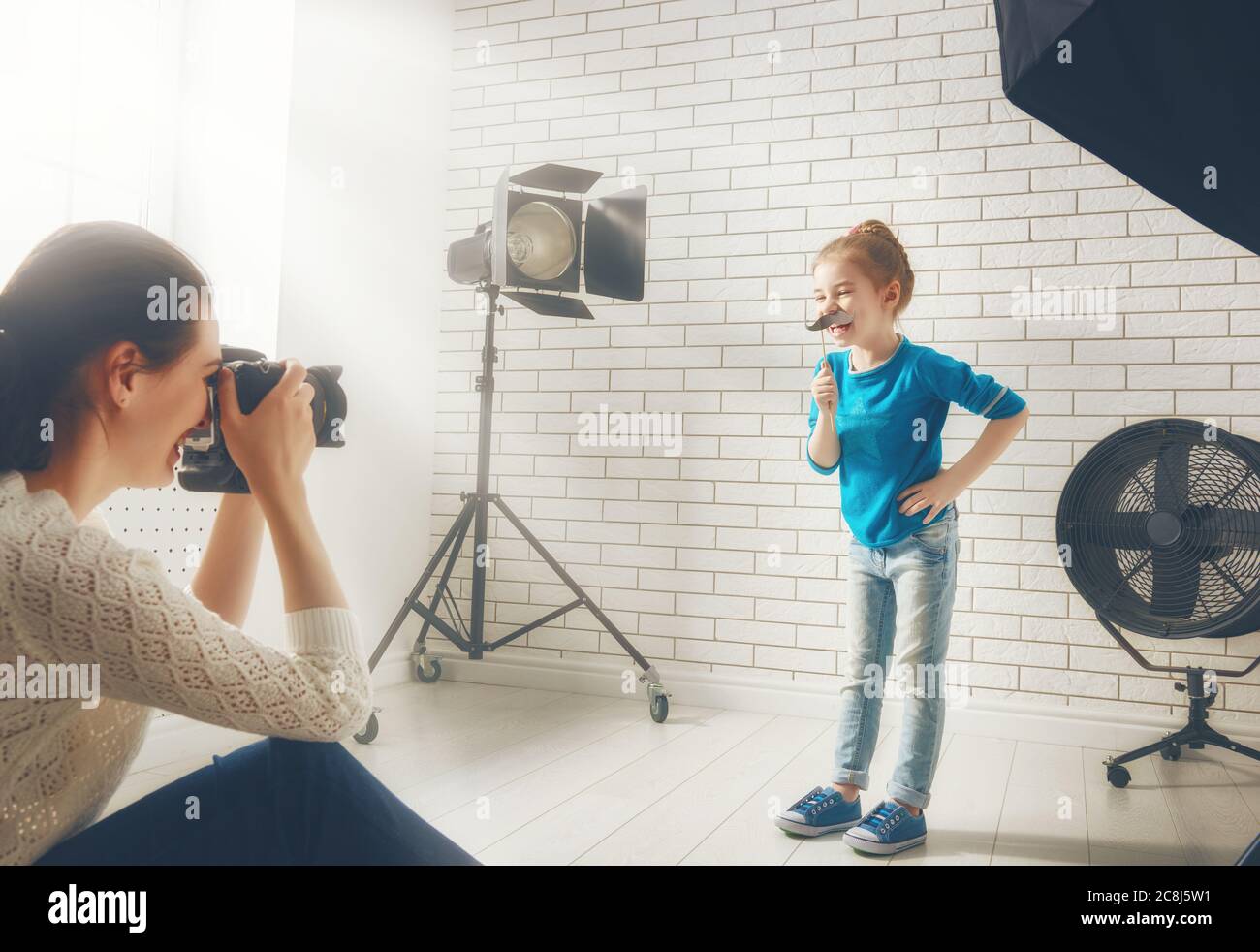 Photographer in motion. Young woman photographer and child girl having ...