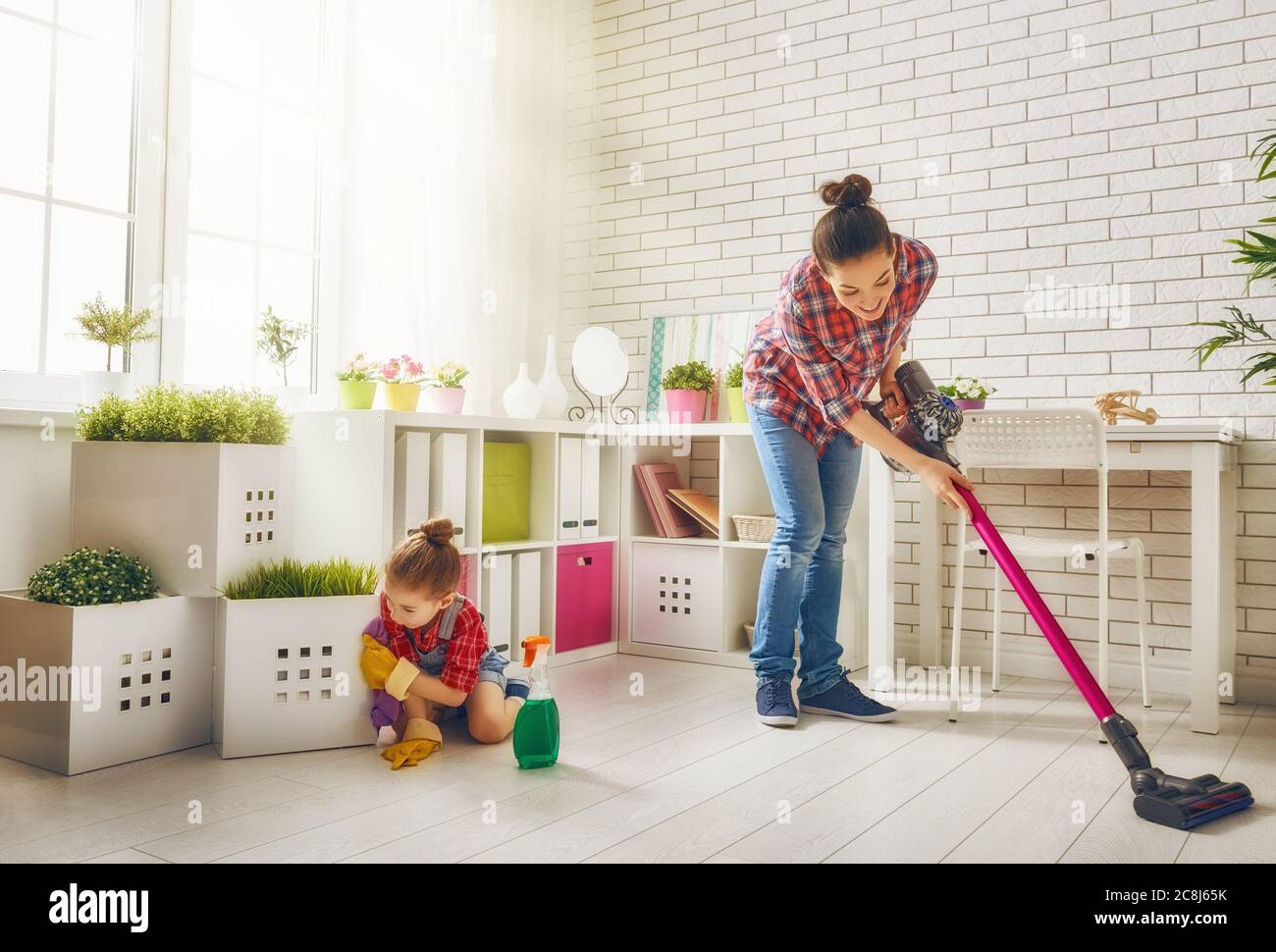 Happy family cleans the room. Mother and daughter do the cleaning in ...