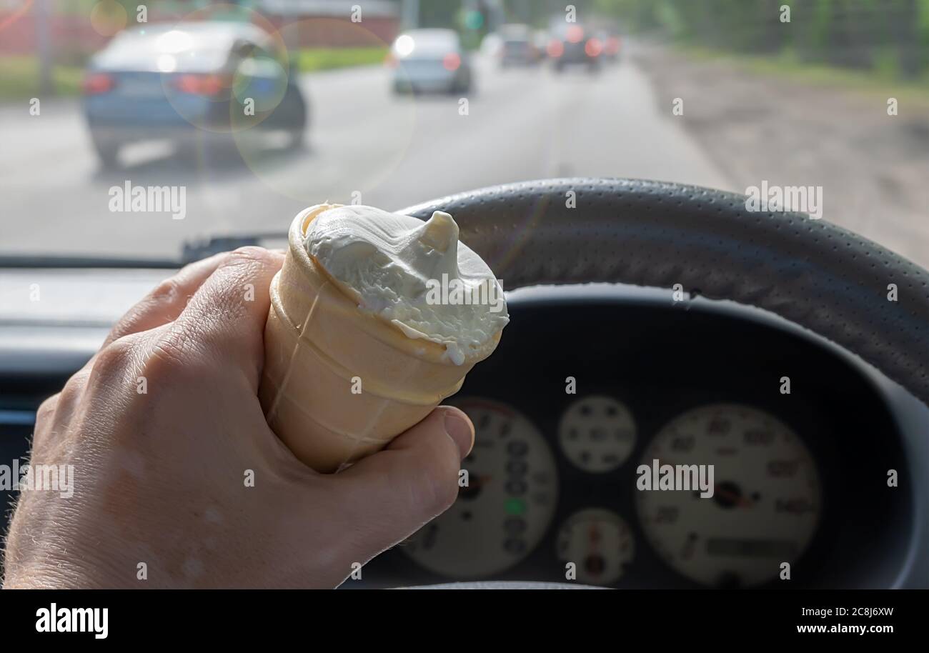 ice cream in the hand of the driver of the car against the background ...