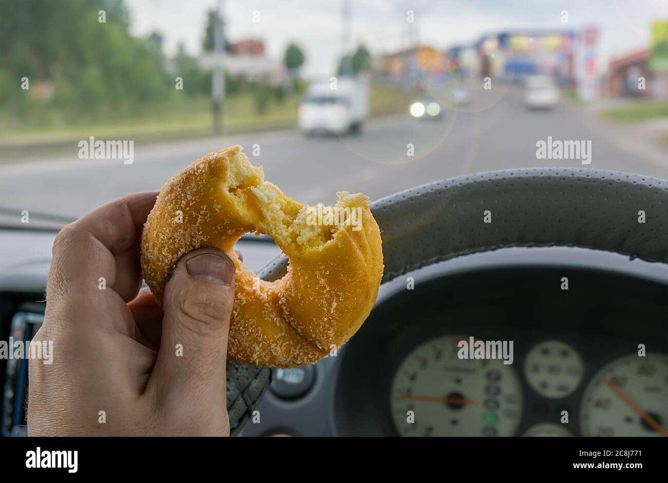food, cookies, sweet bagel in the hand of a car driver while driving ...
