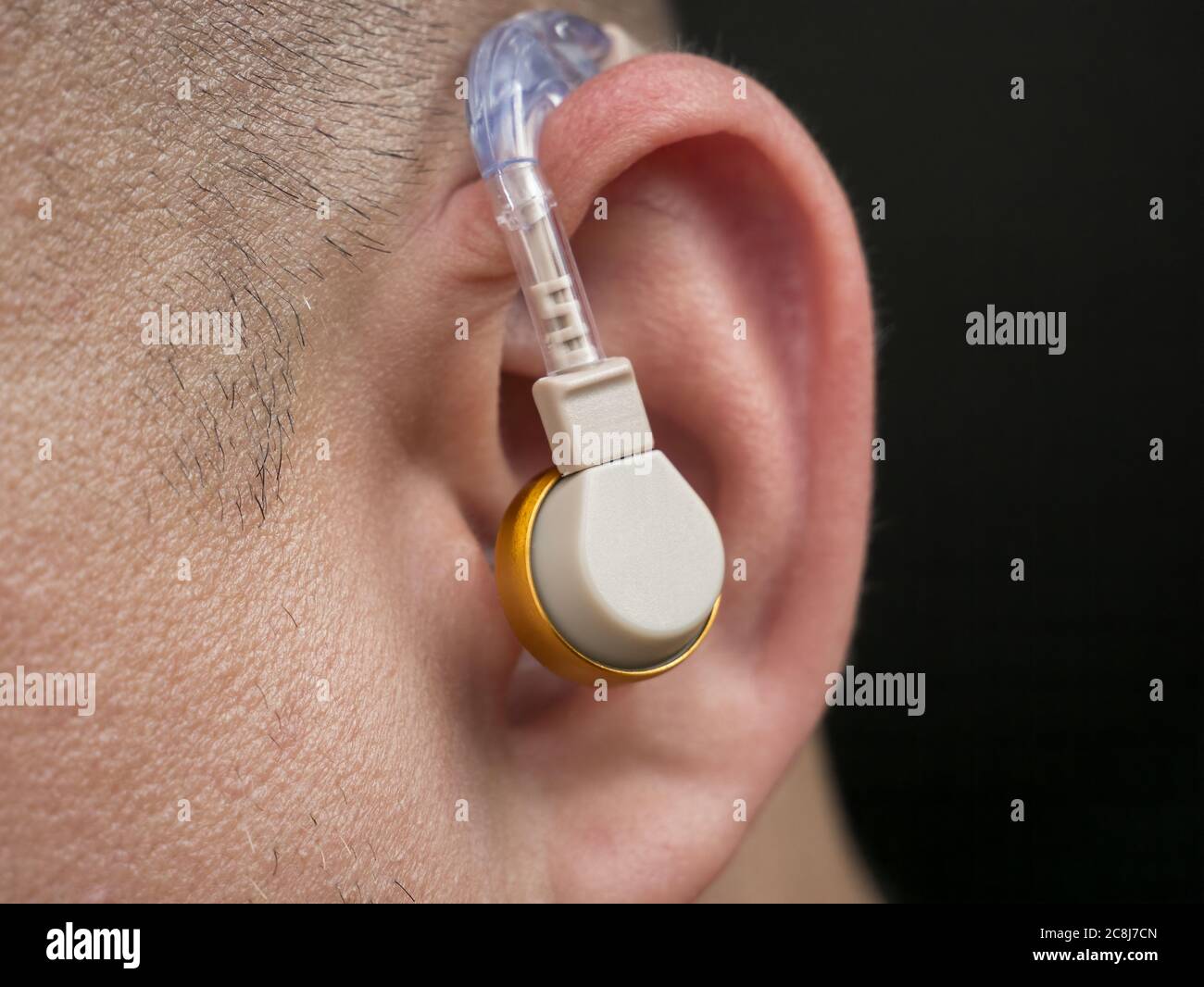 Hearing aid in the ear of a man with suffering from deafness and ...