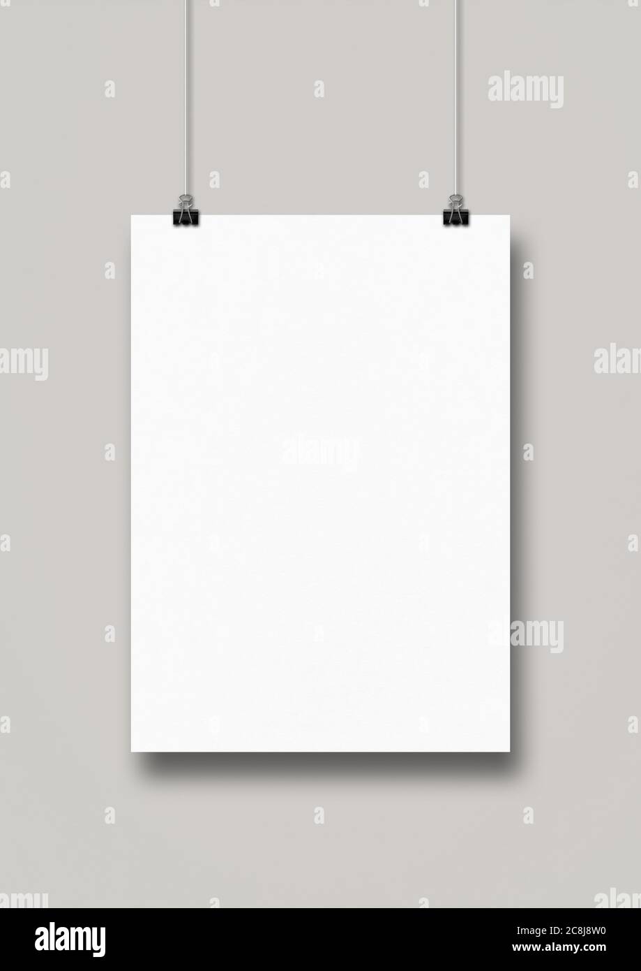White poster hanging on a clean wall with clips. Blank mockup template ...