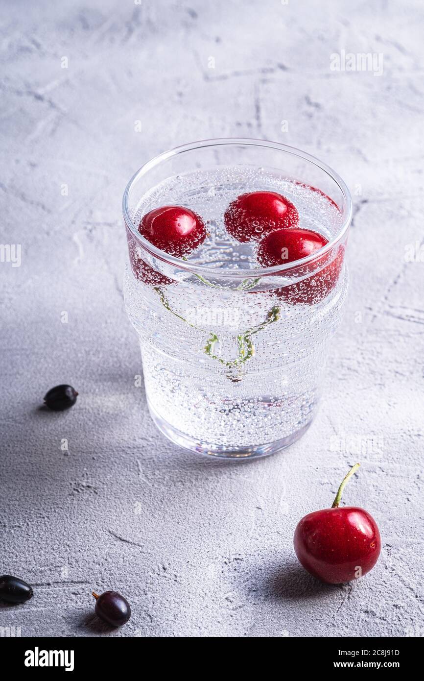 Fresh cold sparkling water drink with cherry, raspberry and currant ...