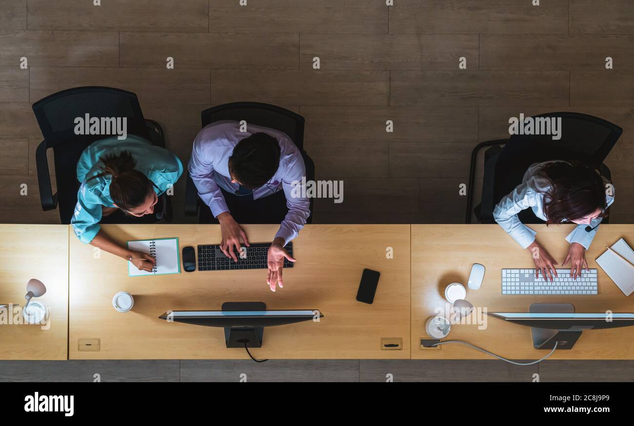 Top view of Asian Male customer care service working hard late in night ...