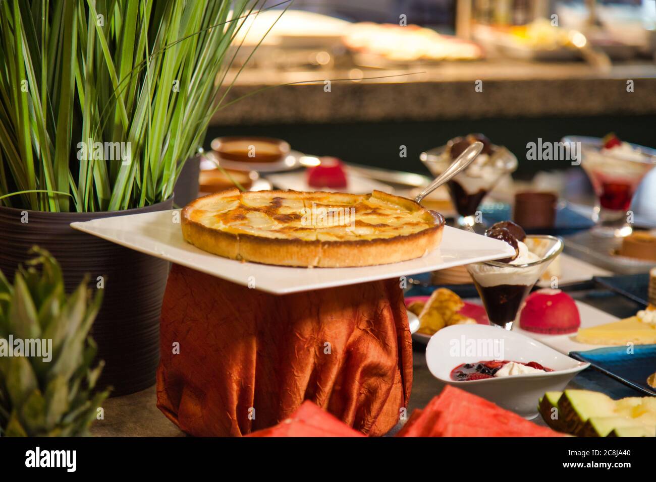 Cheesecake on a buffet table full of desserts such as fruit, cakes and ...