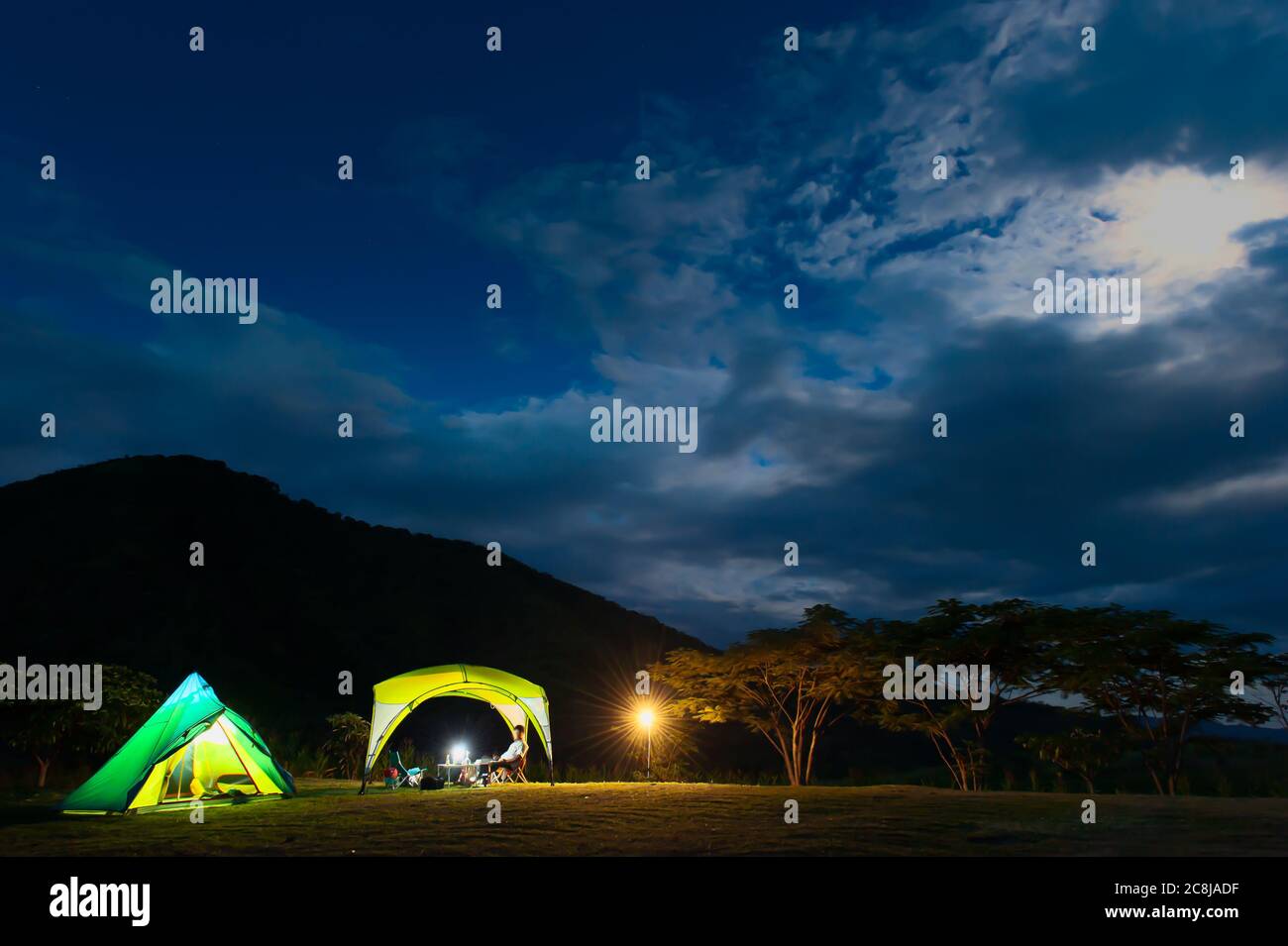 Landscape of illuminated camp tents under the moonrise, camping on a ...