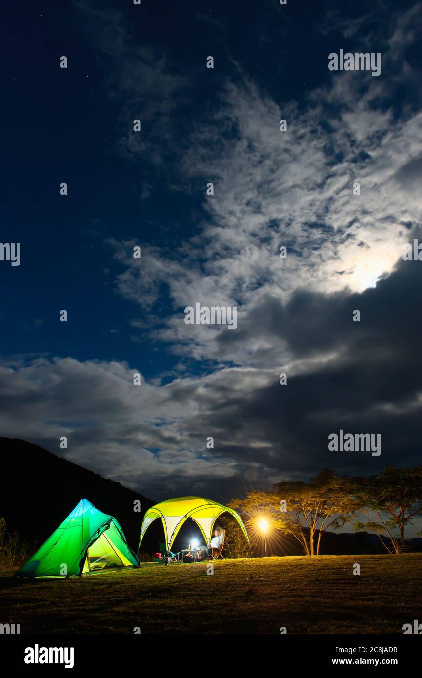 Landscape of illuminated camp tents under the moonrise, camping on a ...