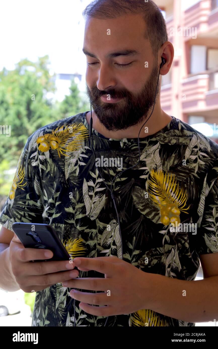 handsome young man is listen music on the phone Stock Photo - Alamy