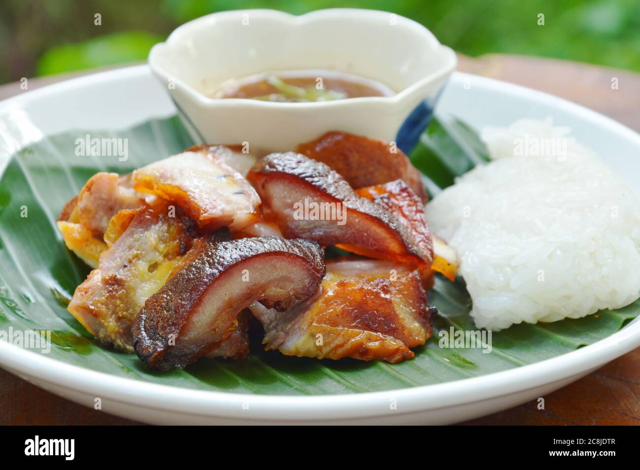 barbecue pork belly with sticky rice and dipping spicy sauce on plate ...