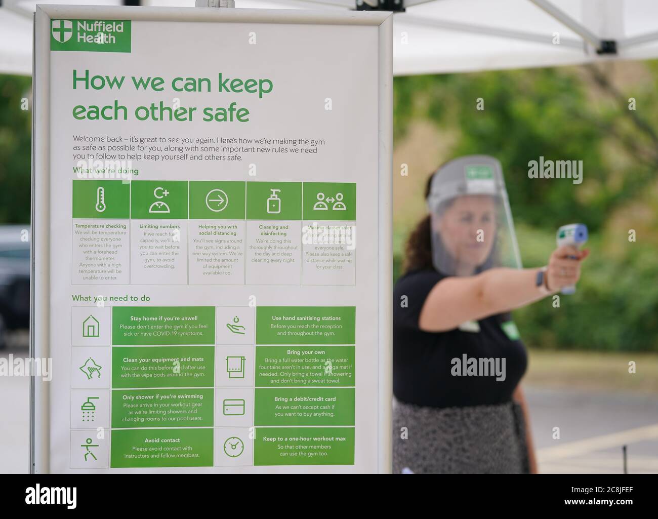 A staff member prepares to check a gym members temperature at Nuffield ...