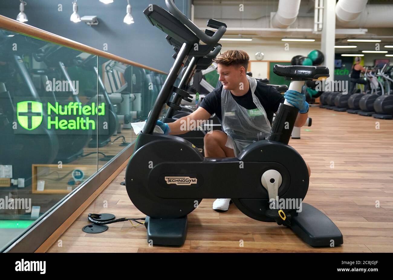 A member of staff cleans the exercise equipment at Nuffield Health ...