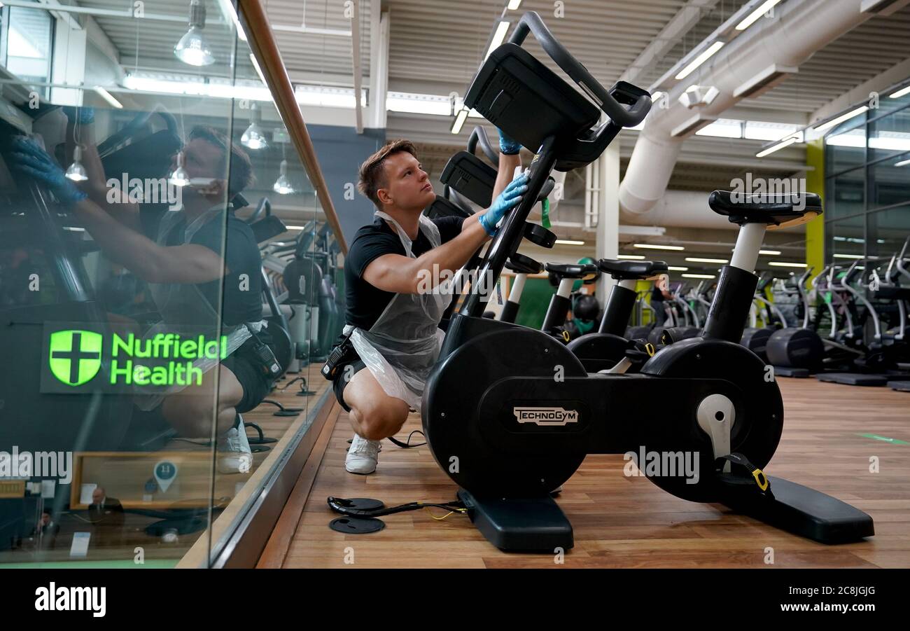 A member of staff cleans the exercise equipment at Nuffield Health ...