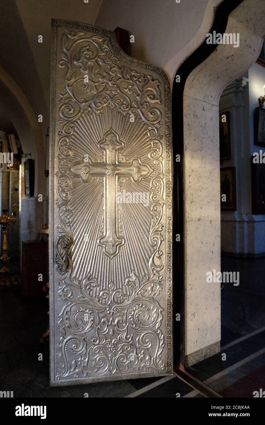 Silver door decorated with a christian cross and ornate handle at the ...