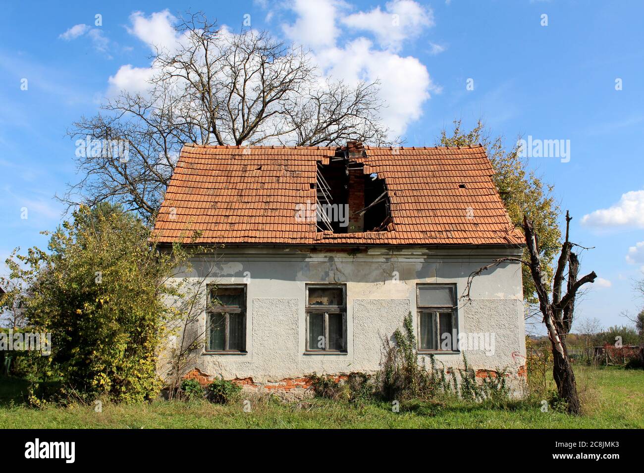 Abandoned small suburban family house ruins with large hole in middle ...