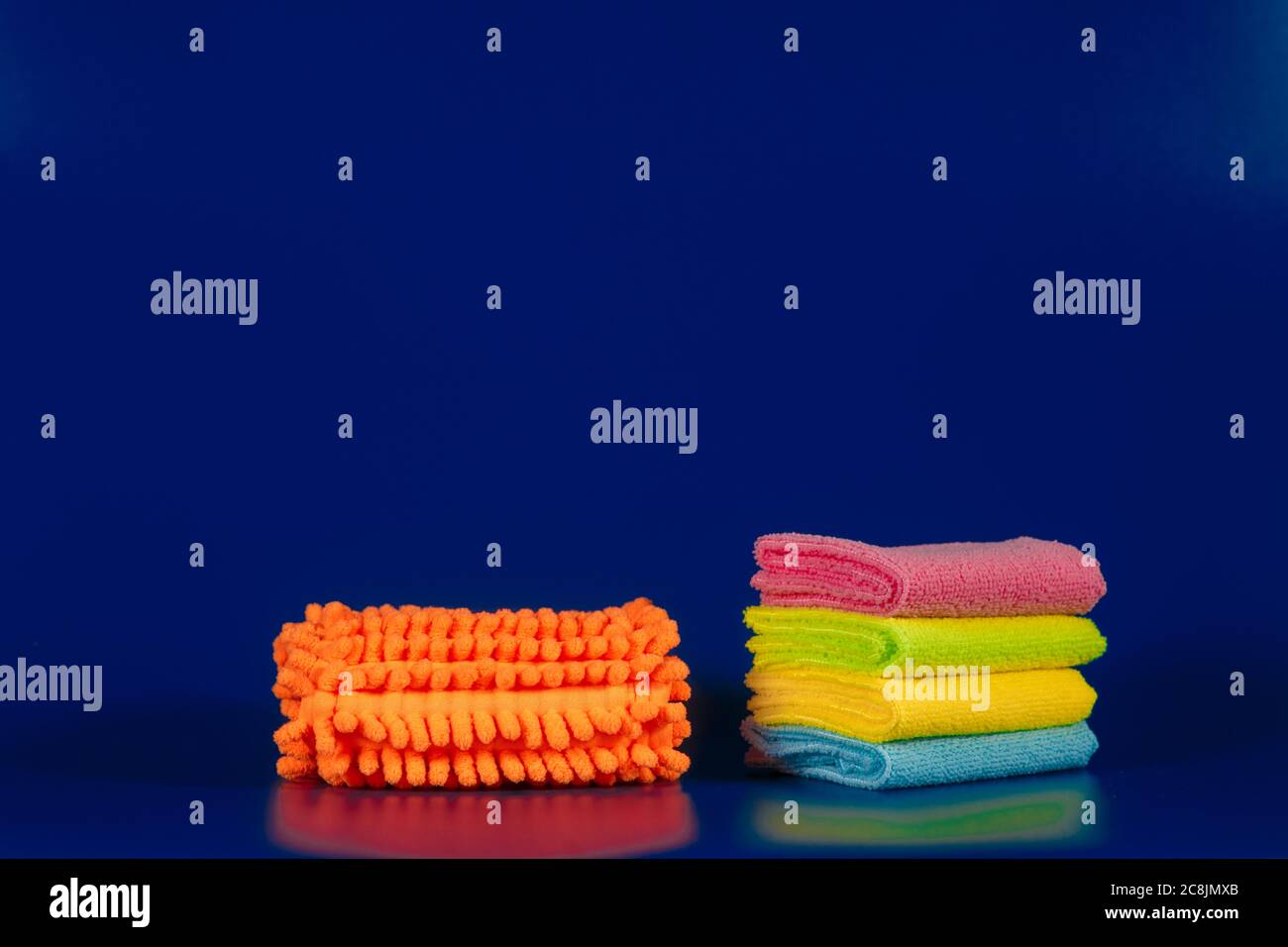 washing rags of different colors on a blue background Stock Photo - Alamy