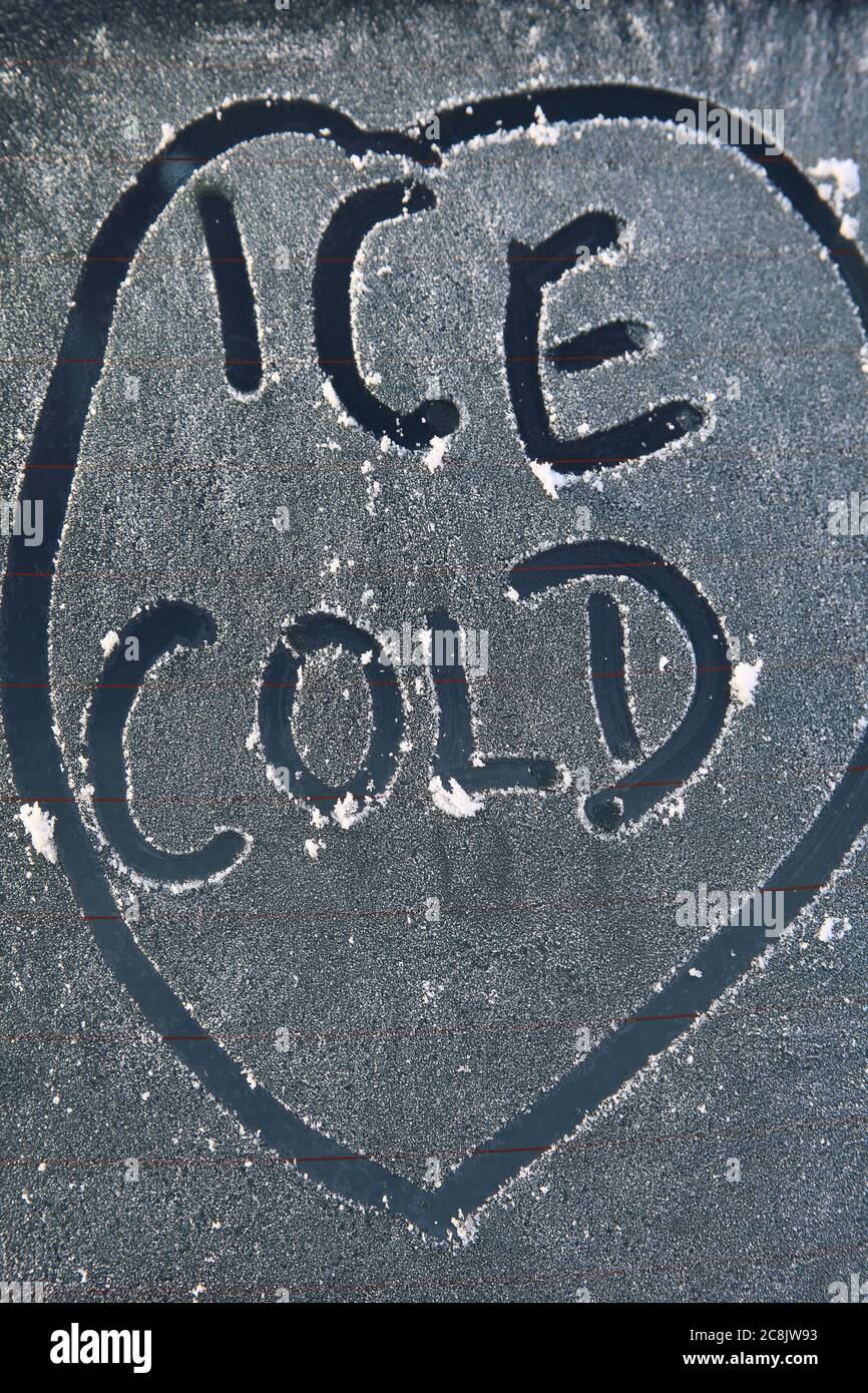 Frozen car window with a frost ice cold message text sign in the winter ...