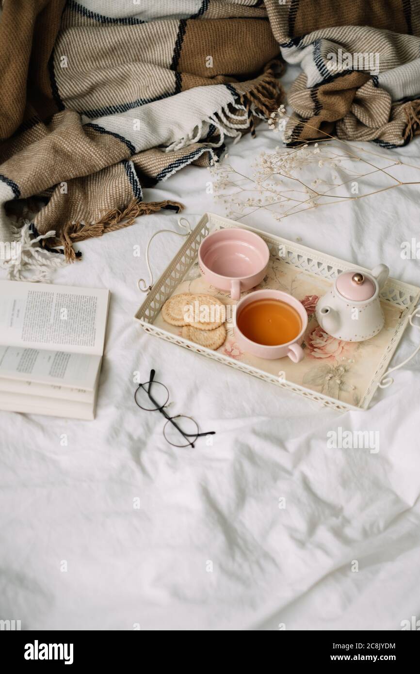 Kettle with tea and cups on a tray. Breakfast at home in bed, coziness ...
