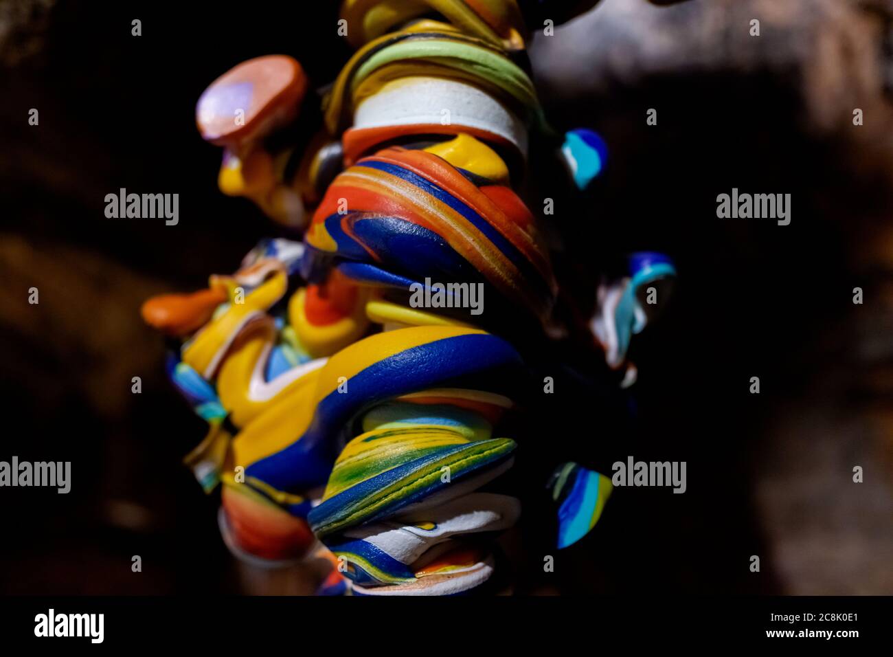 Twisted plastic material with rounded color mix, isolated on black ...