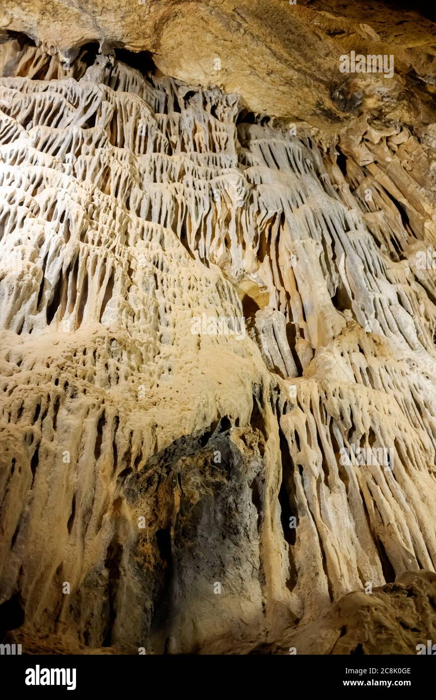 Stalactite and stalagmite formations on the rocky walls of a large ...