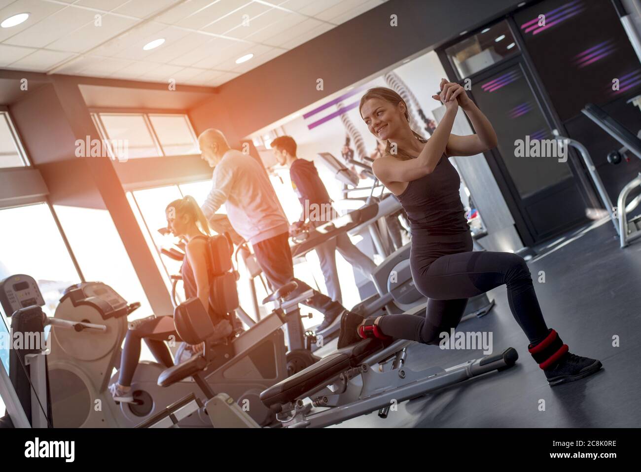 People exercising in a gym indoors and the sunlight falls out of the ...