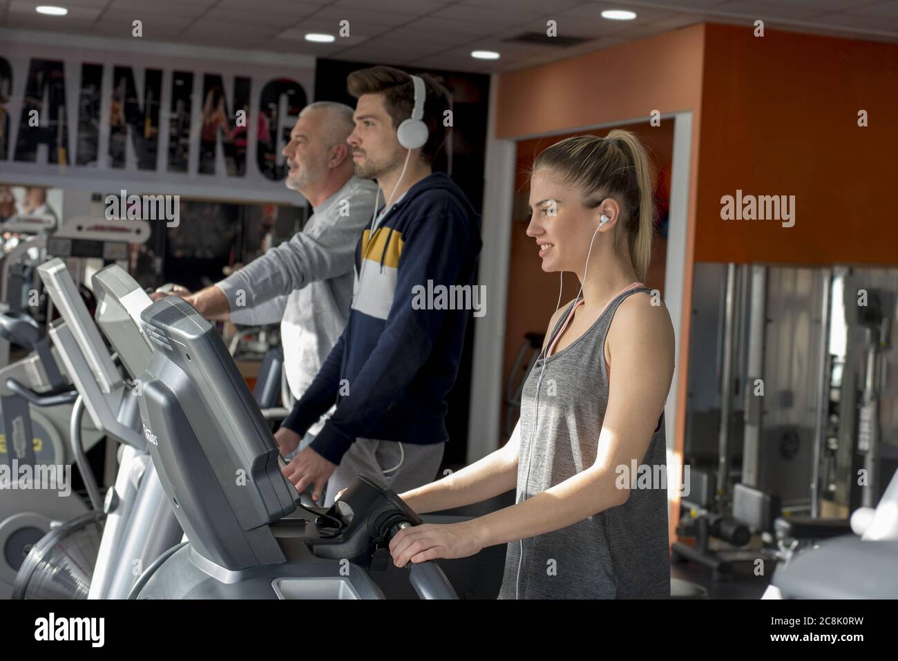 Group of smiling people exercising together on treadmills at the gym ...