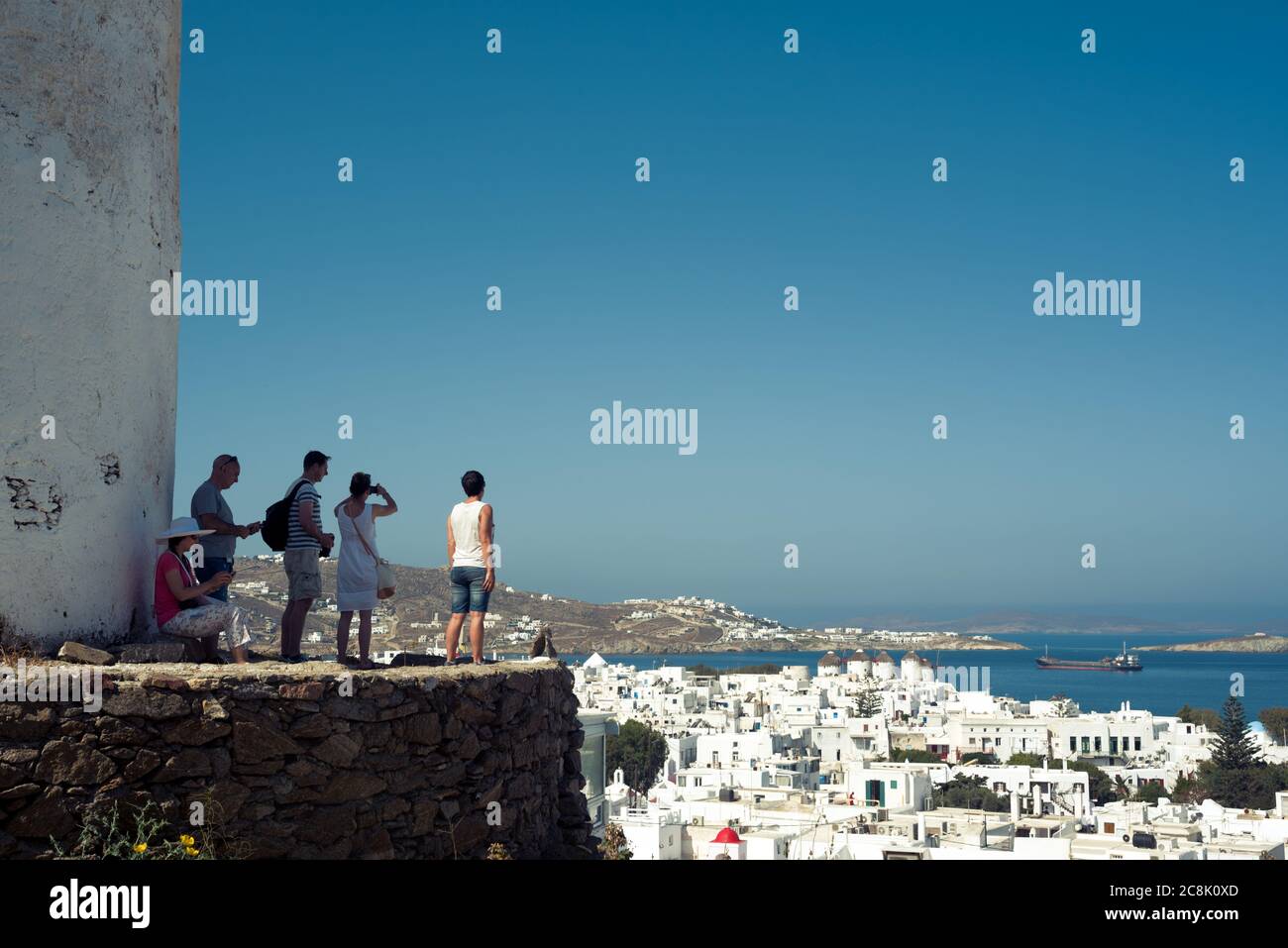 Group of travelers watch panoramic view of Mykonos Stock Photo - Alamy