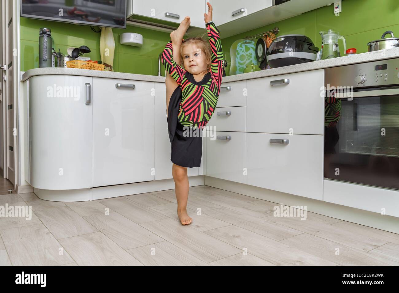 beautiful girl 4 years old in a gymnastic leotard is engaged in ...