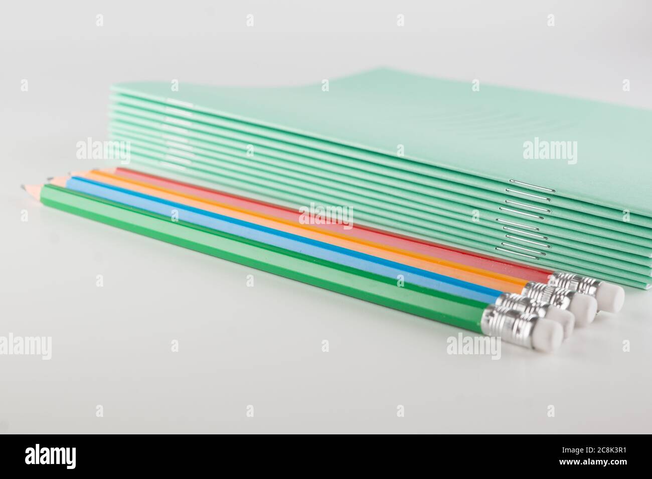 stack of thin student notebooks with colored pencils for school Stock ...