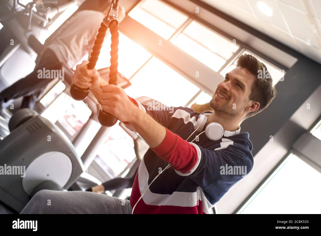 Young male doing hand stretching exercises with a rope at the gym Stock ...