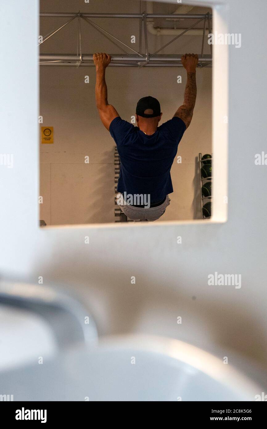 Man does pull ups in a gym seen through a window Stock Photo - Alamy