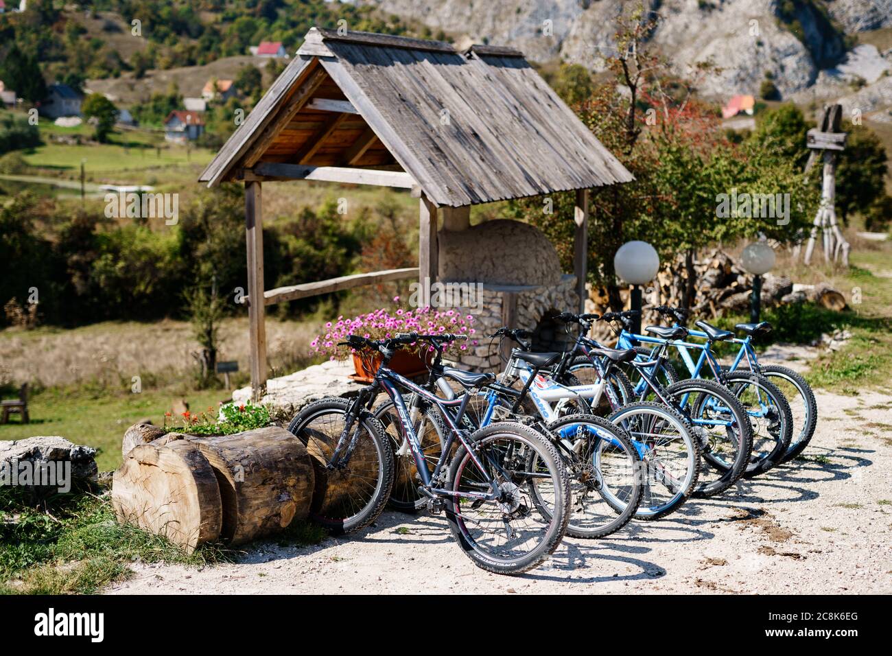 A parking lot for bicycles in a fallen log by an old stone oven Stock ...