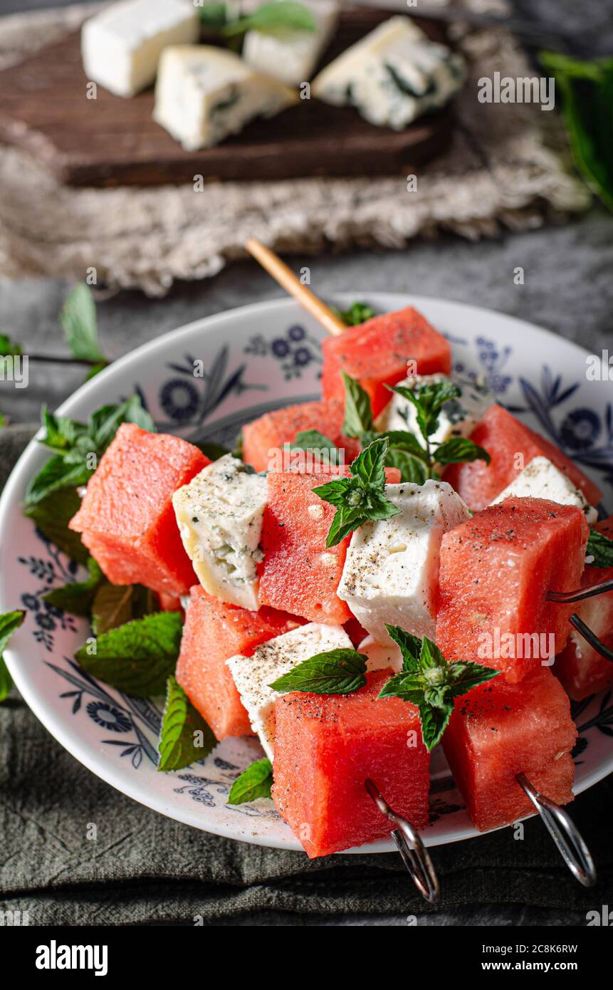 Fresh melon with feta and blue cheese, topped with herbs Stock Photo ...