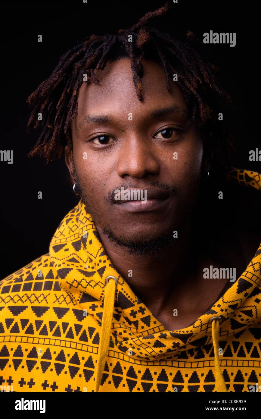 Young African man with dreadlocks against black background Stock Photo ...