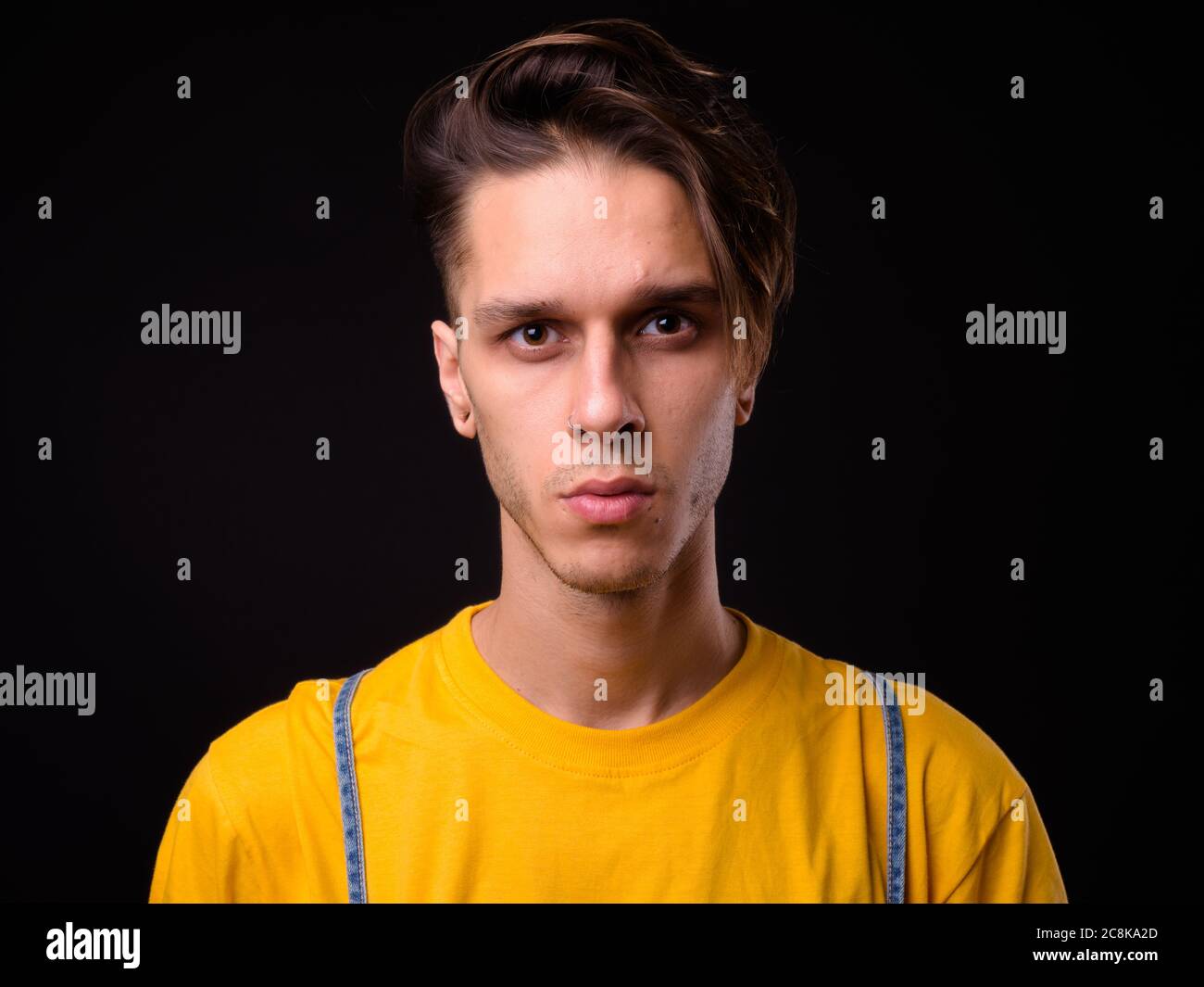 Young handsome rebellious man against black background Stock Photo - Alamy