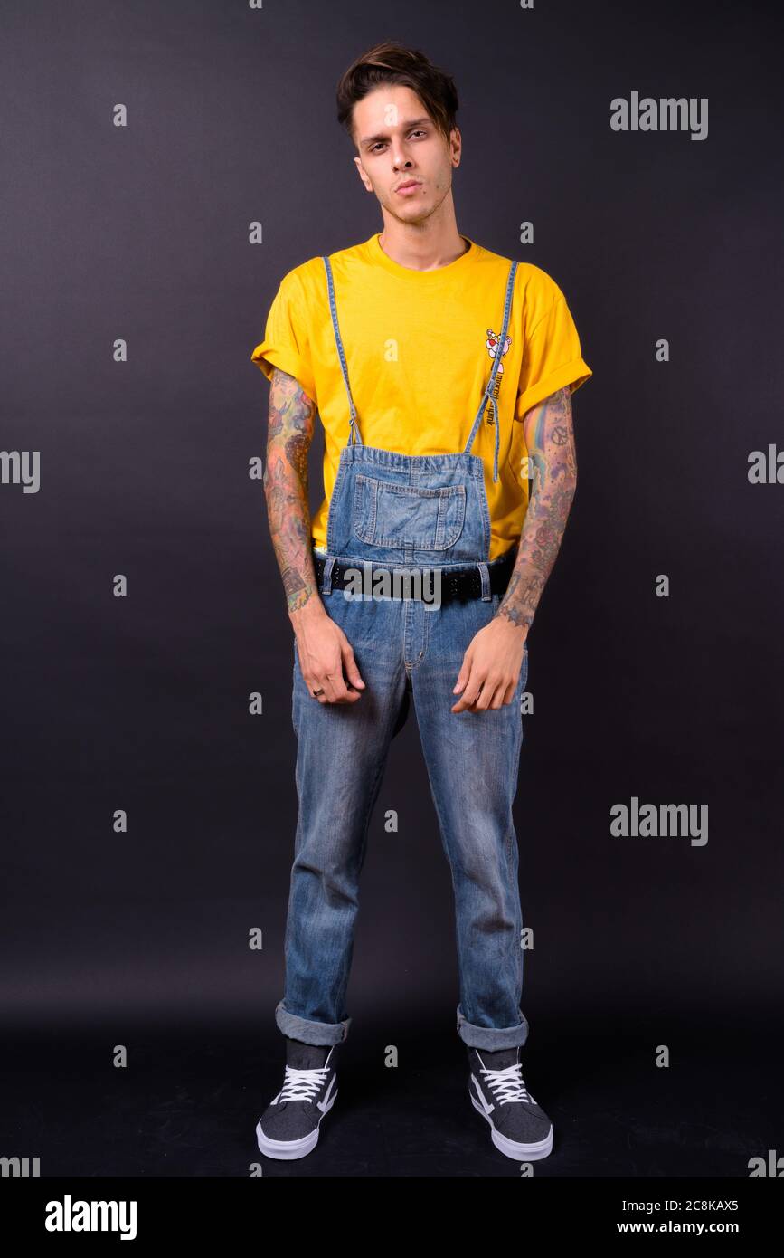 Young handsome rebellious man against black background Stock Photo - Alamy