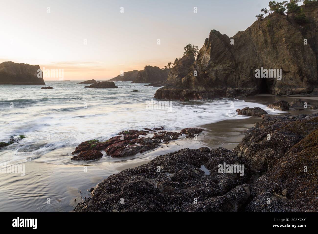 The sun sets on Secret Beach in the southern Oregon coast at sunset ...