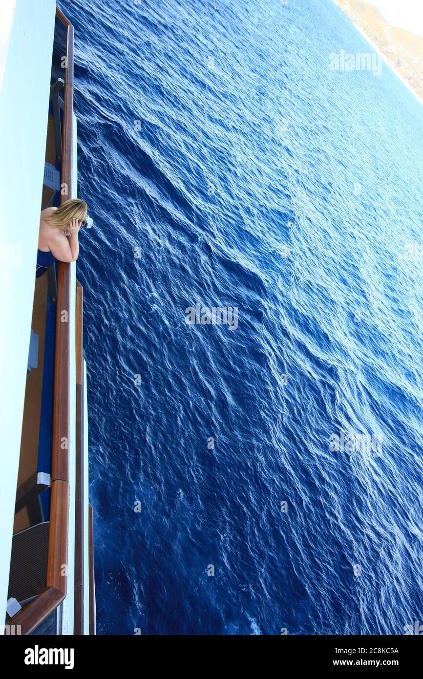 Fun vacation on a cruise ship with person looking out at sea from deck ...