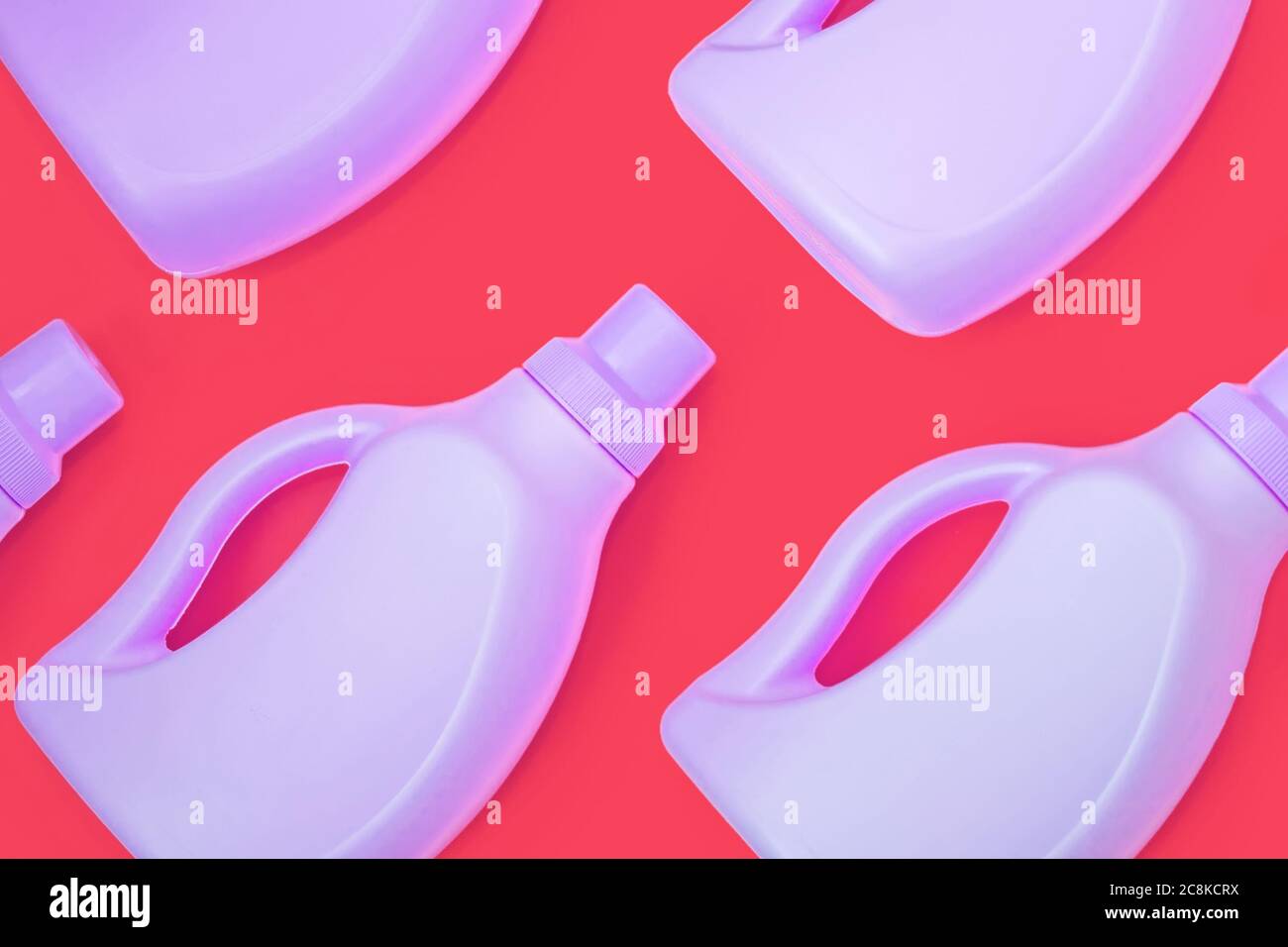 Purple bottles with chemicals for cleaning on a red background ...