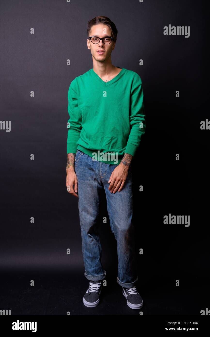 Young handsome rebellious man against black background Stock Photo - Alamy
