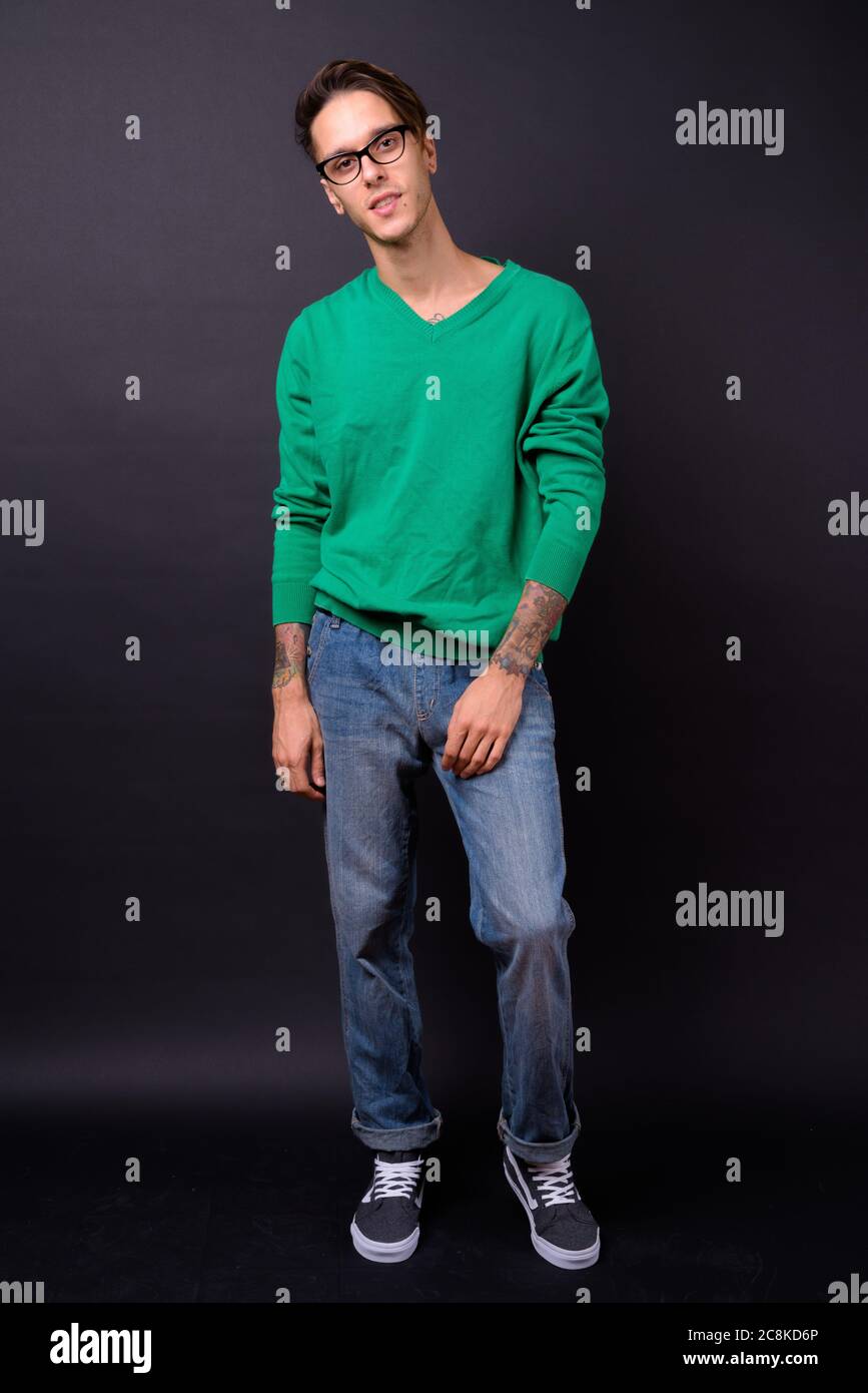 Young handsome rebellious man against black background Stock Photo - Alamy