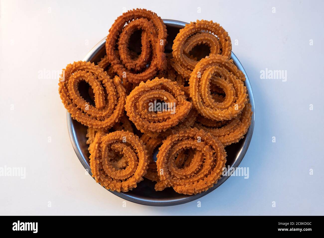 a top shot of Indian homemade chakali snacks isolated on white ...