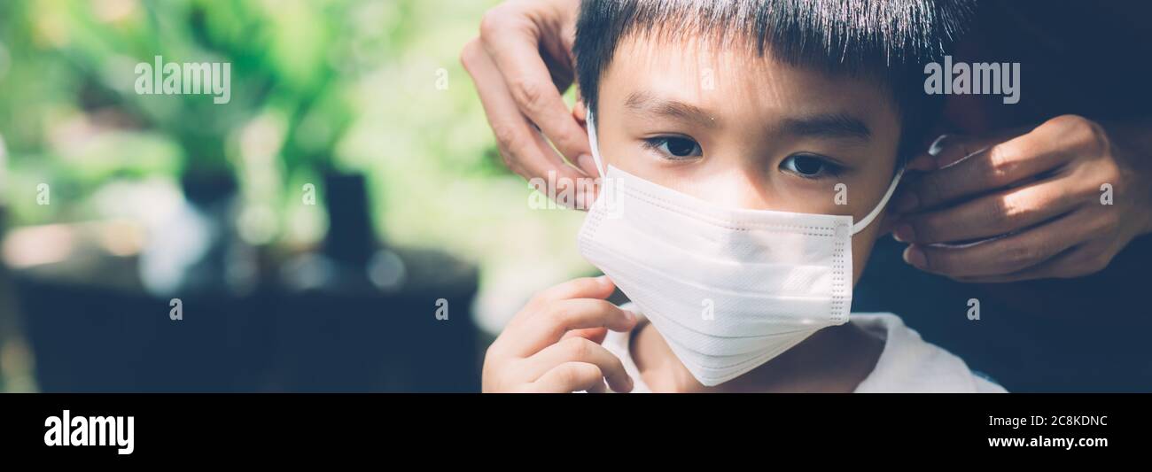 Mother take care son with face mask for protection disease flu or covid ...