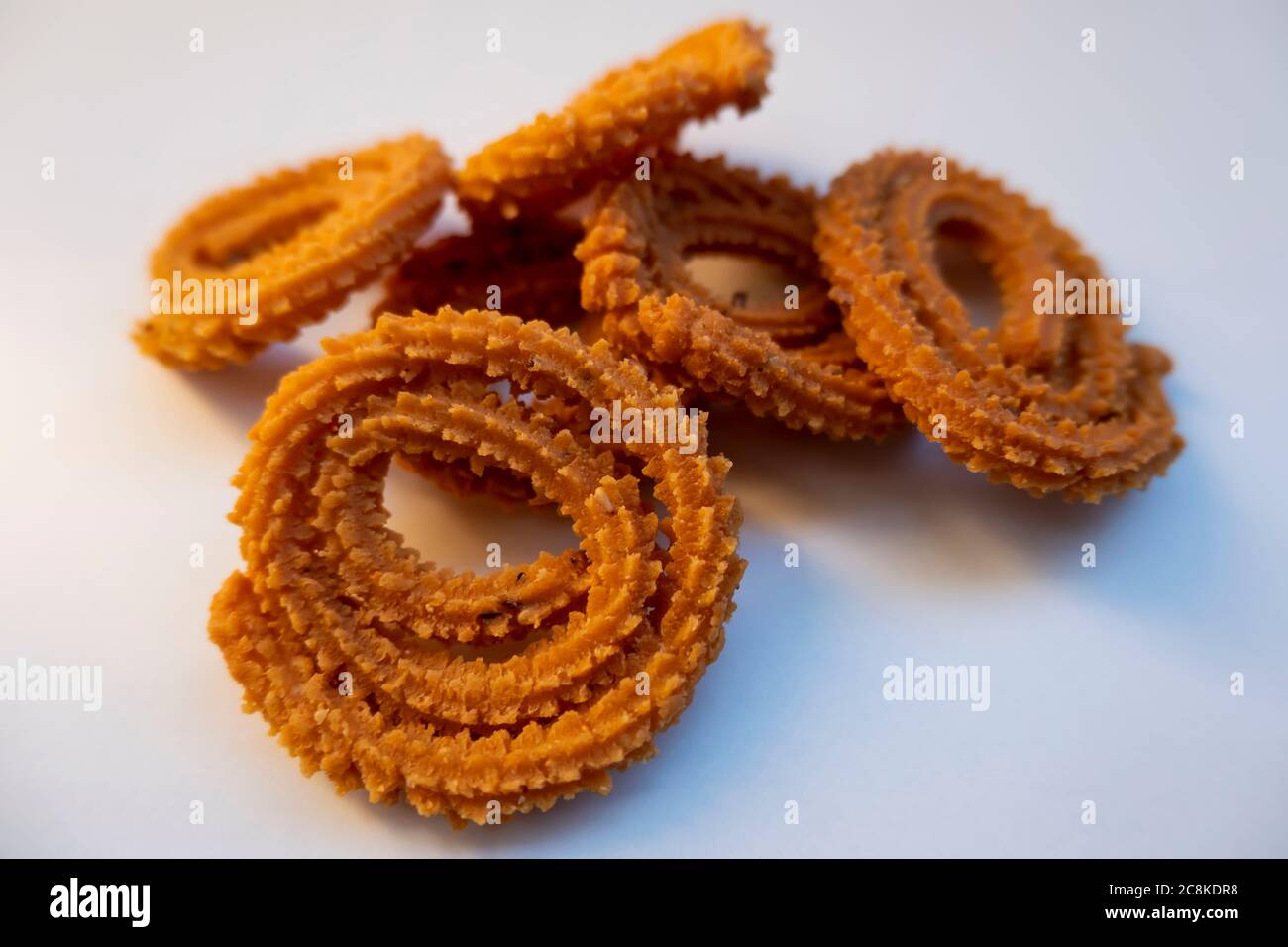 a closeup view of homemade muruku snacks isolated on white background ...