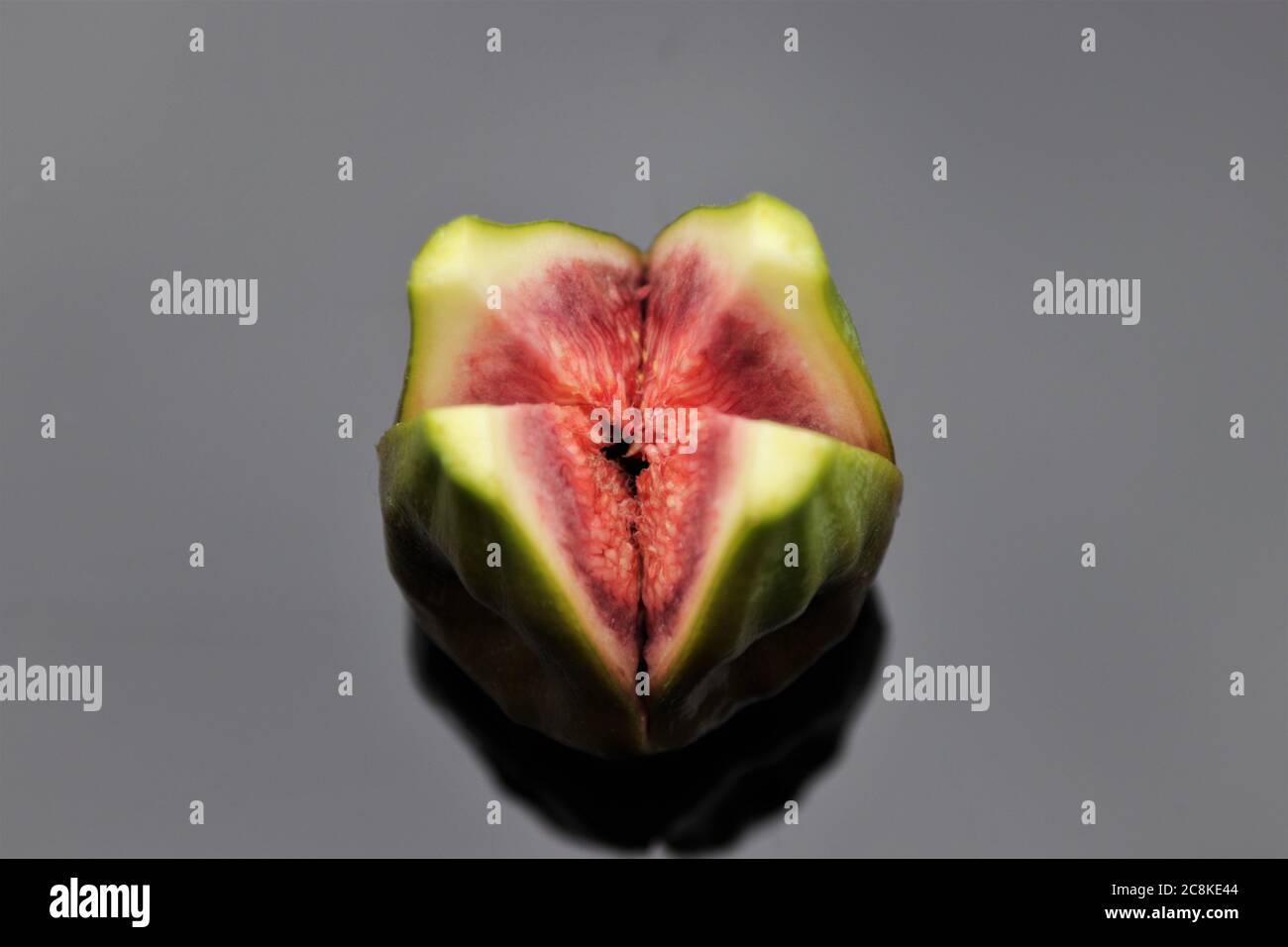 A single ripe green fig split into quarters Stock Photo - Alamy