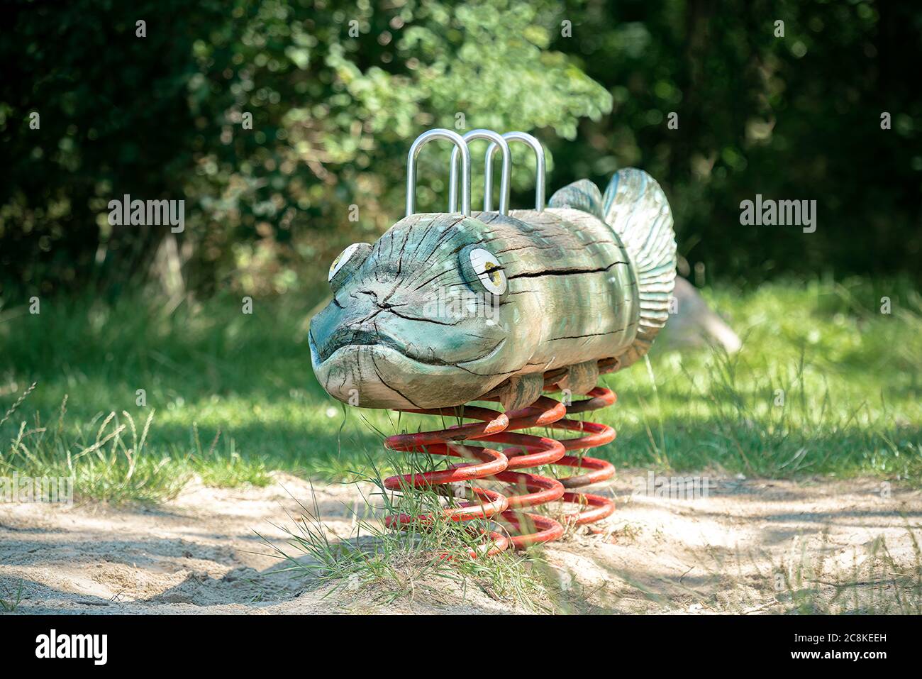 Wooden hand crafted fish spring rocker in a playground Stock Photo - Alamy
