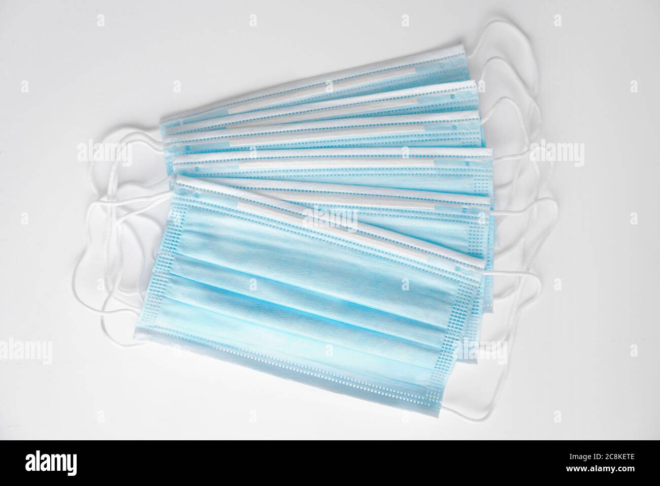 Blue medical masks lie on a white table - face mask against bacteria ...