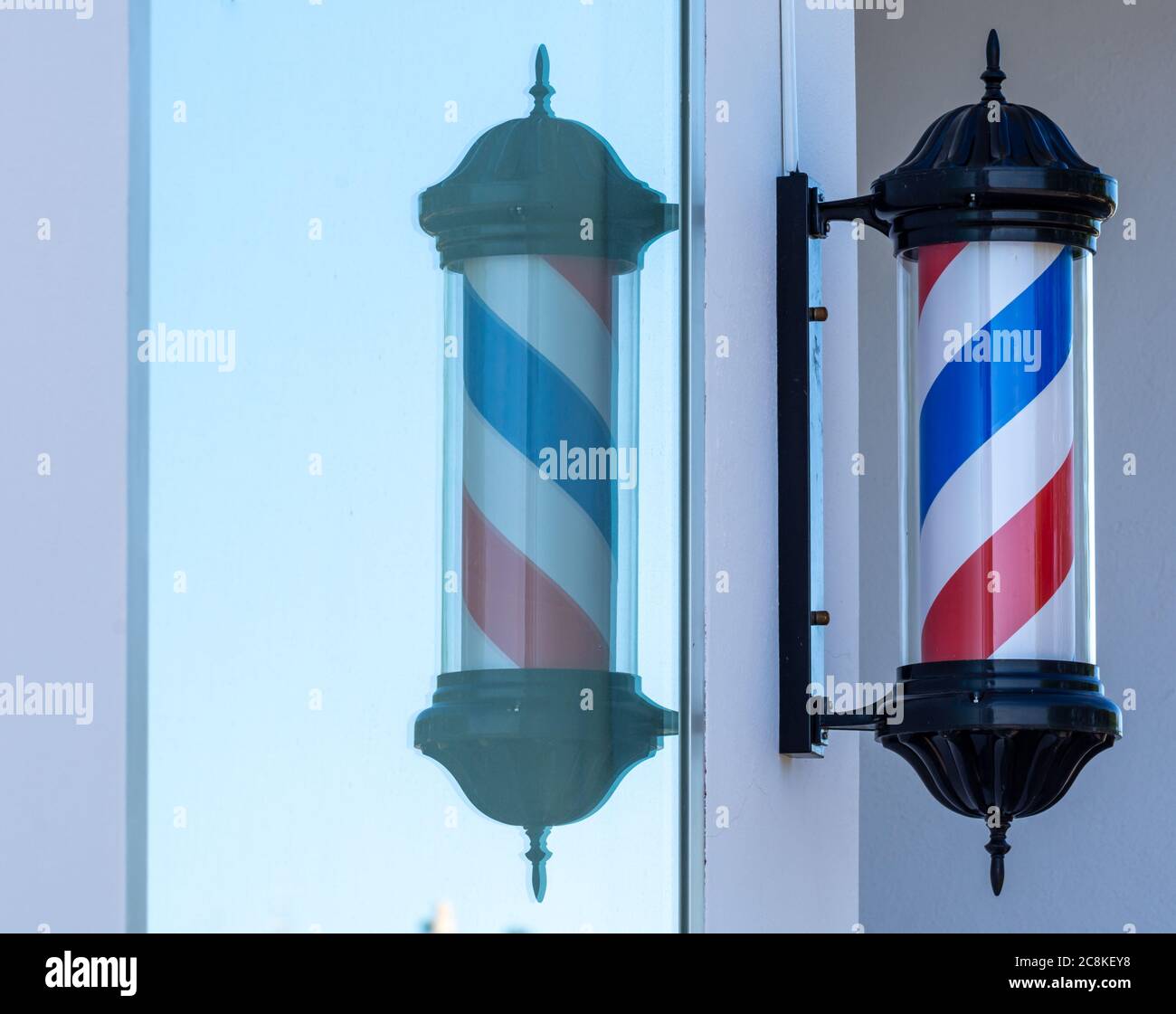Rotary cylinder of a barber shop and its reflection in the glass of a ...