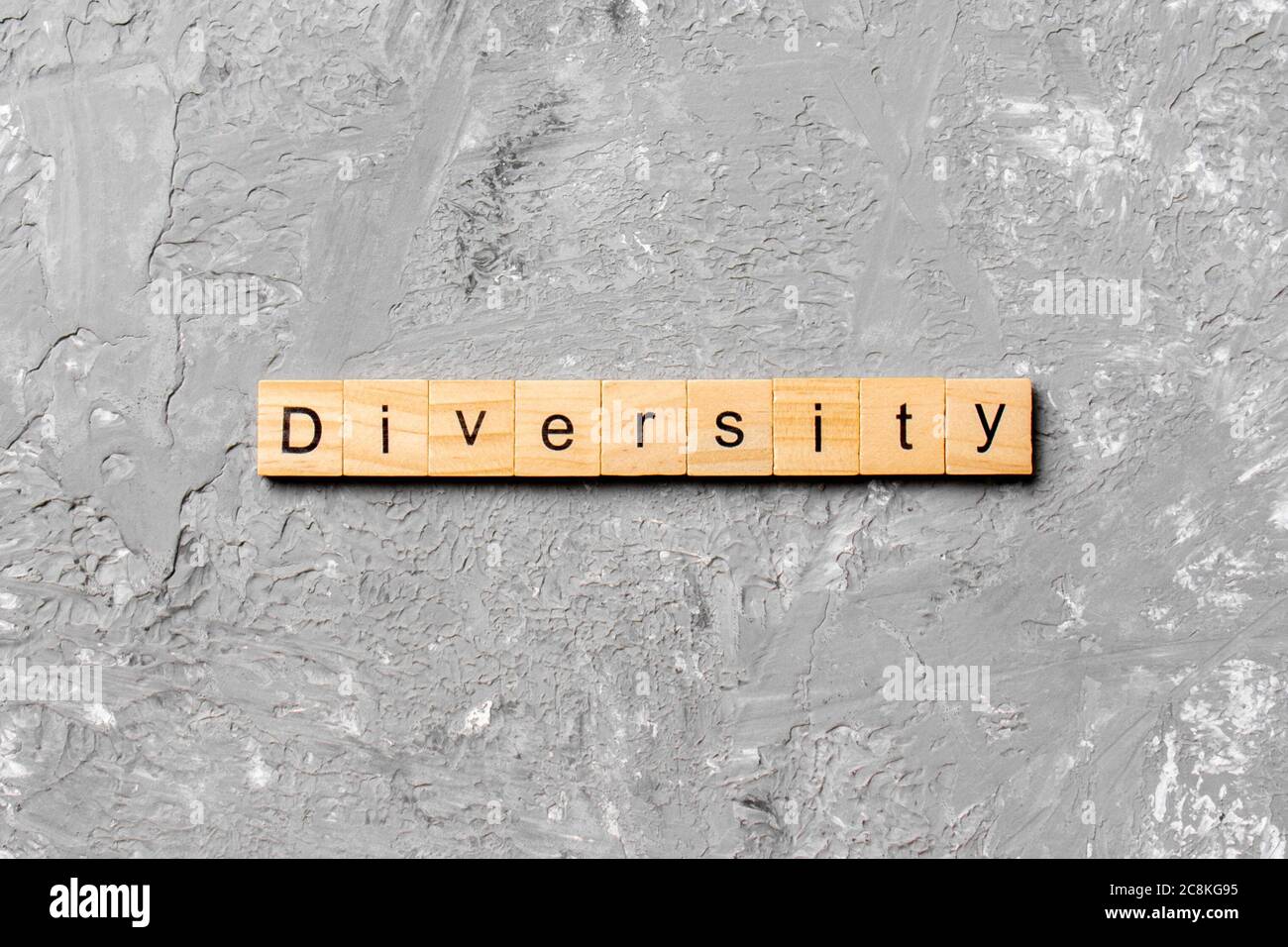 Diversity word written on wood block. Diversity text on cement table ...